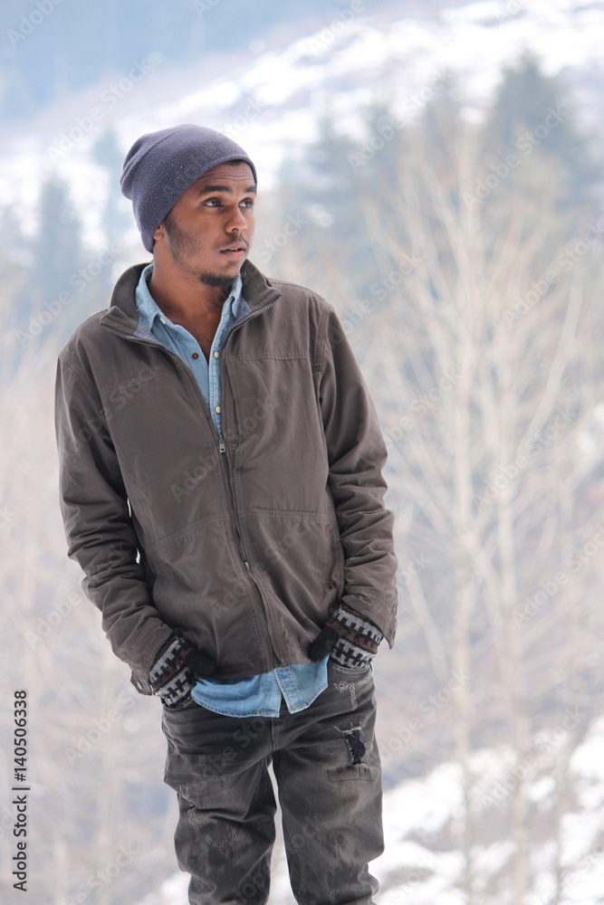 Man standing in the snow wearing a beanie and showing his attitude pose ...
