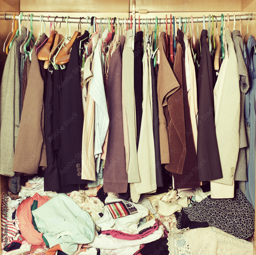 Pile of messy clothes in closet. Untidy cluttered woman wardrobe in ...
