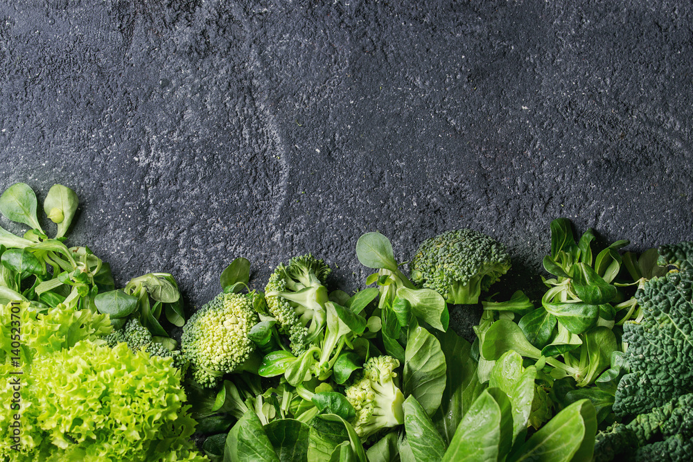 Variety of raw green vegetables salads, lettuce, bok choy, corn ...
