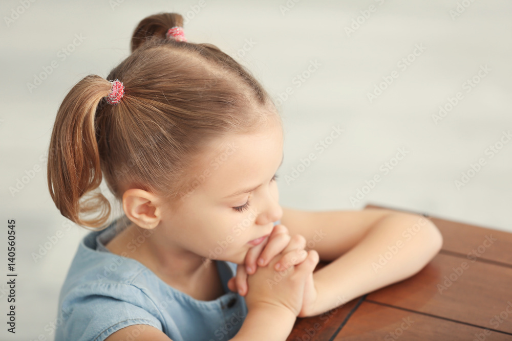 Cute little girl praying at home Stock Photo | Adobe Stock