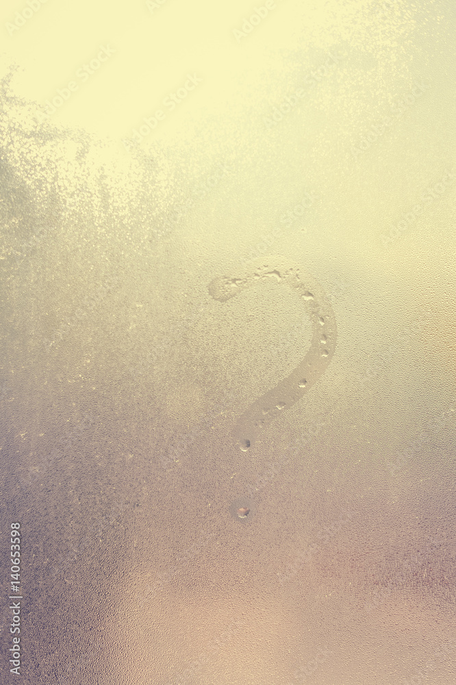 Question mark symbol on sunny foggy window glass blurry condensation ...