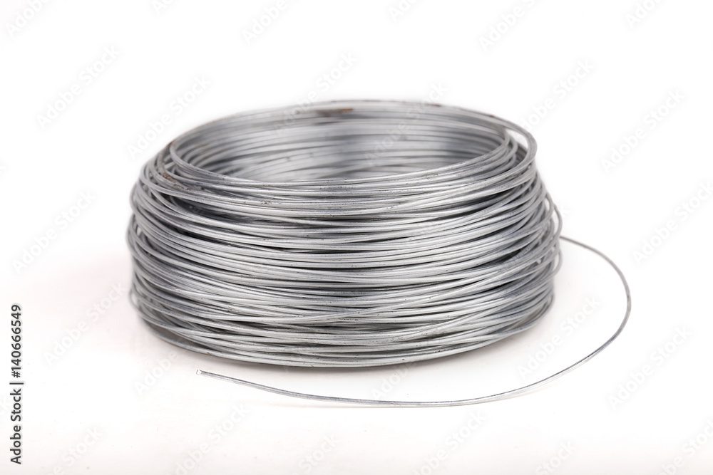 Spool of metal wire on a white surface. Isolated on white background ...