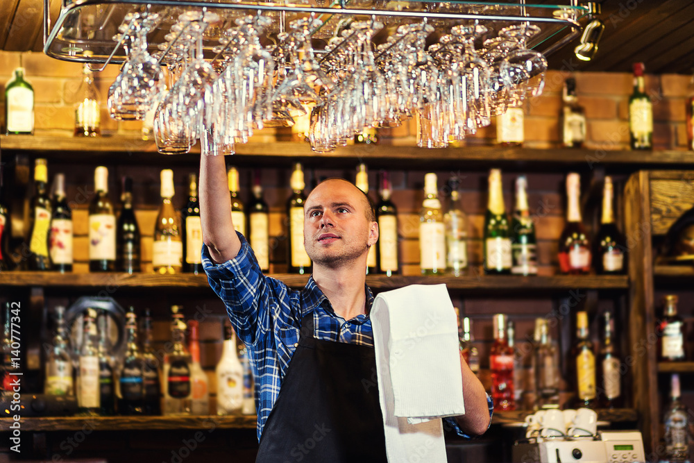 Barman at work in pub,Portrait of cheerful barman worker standing ...
