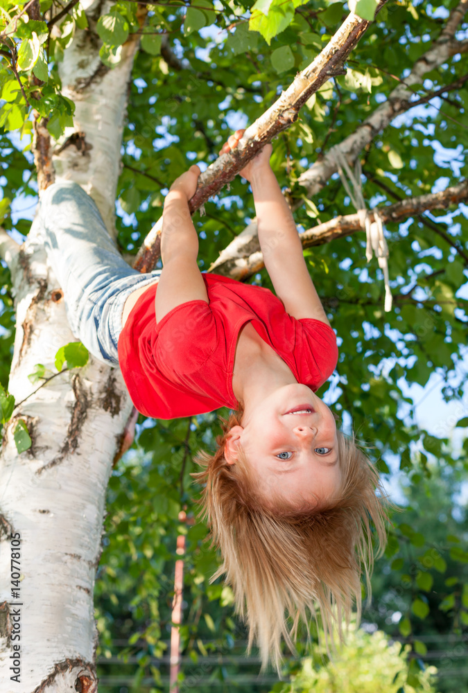 Happy girl hanging from a tree in a summer garden Stock Photo | Adobe Stock