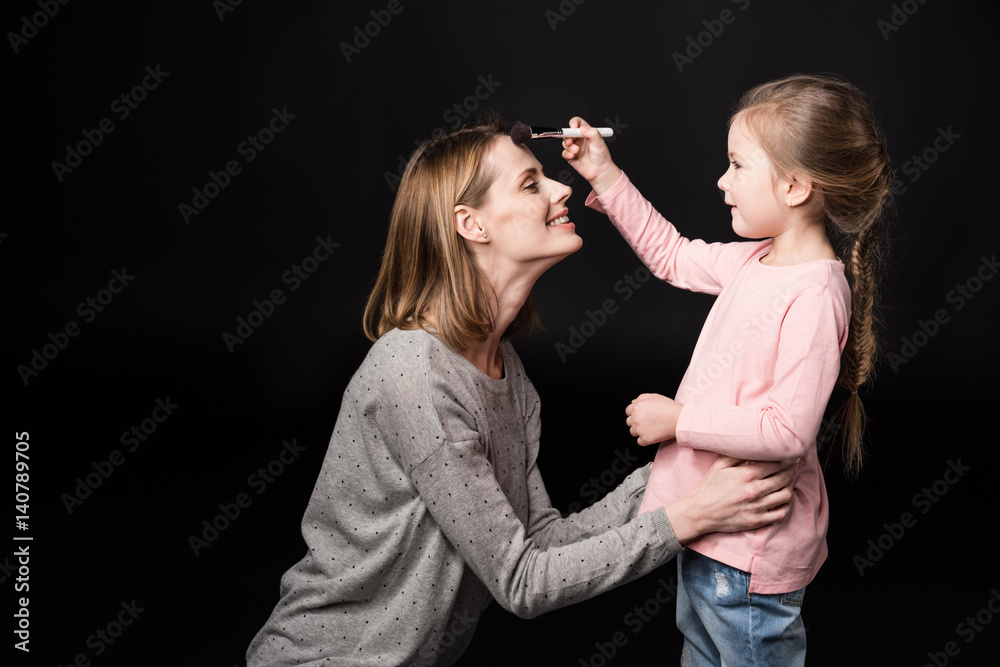 Mother and daughter applying makeup Stock Photo | Adobe Stock