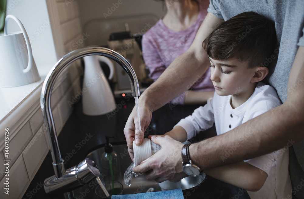 Family cleaning in kitchen Stock-Foto | Adobe Stock