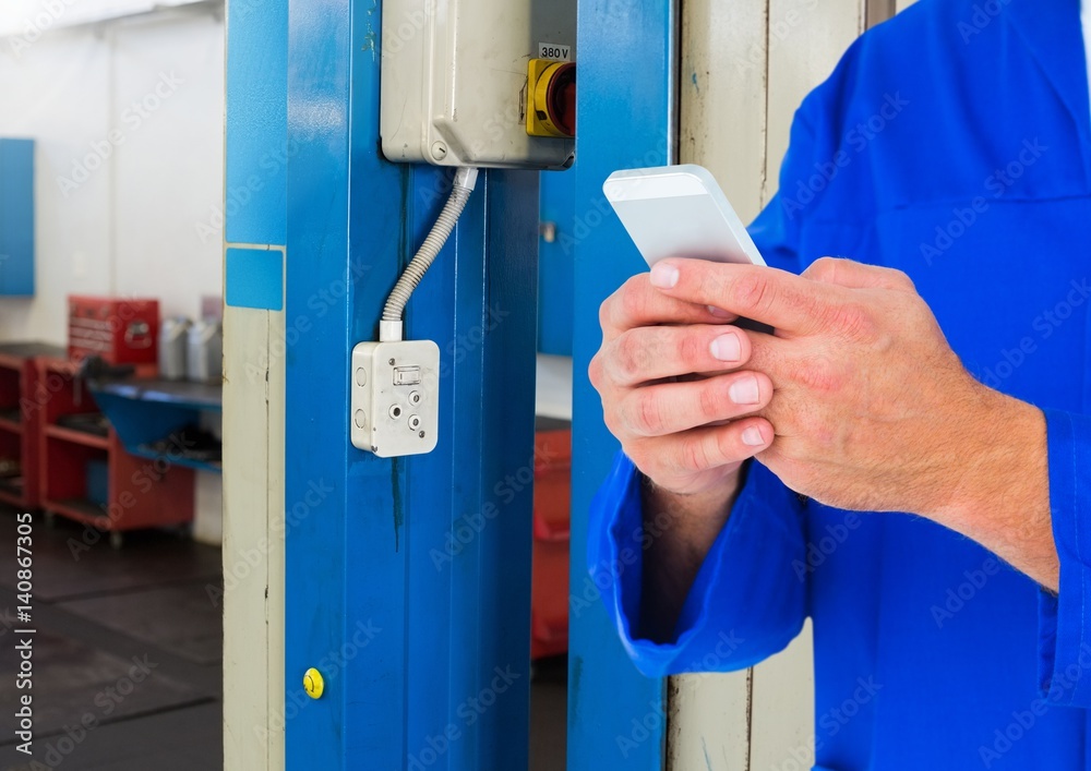 Automobile mechanic using mobile phone in workshop Stock Photo | Adobe ...