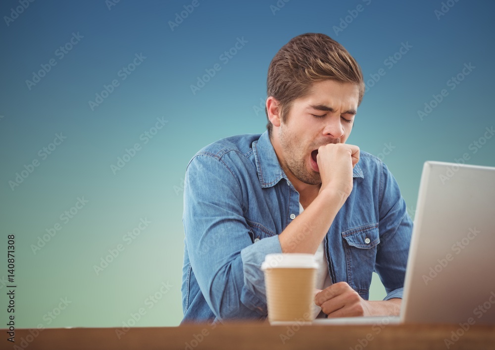 Sleepy man yawning while working on laptop Stock Photo | Adobe Stock