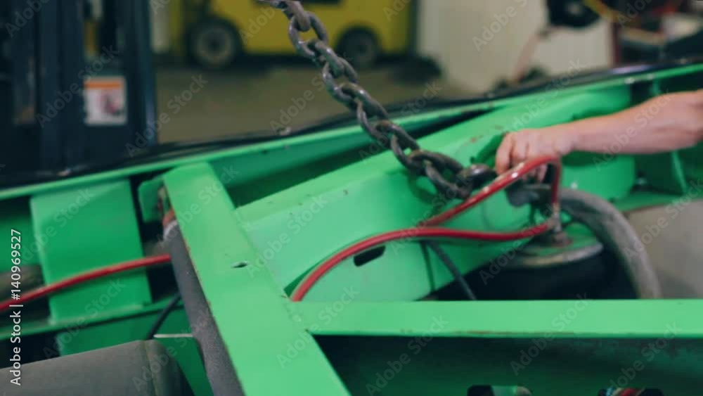 Mechanic Connecting Chain Hook to Truck Suspension in Auto Shop Garage ...