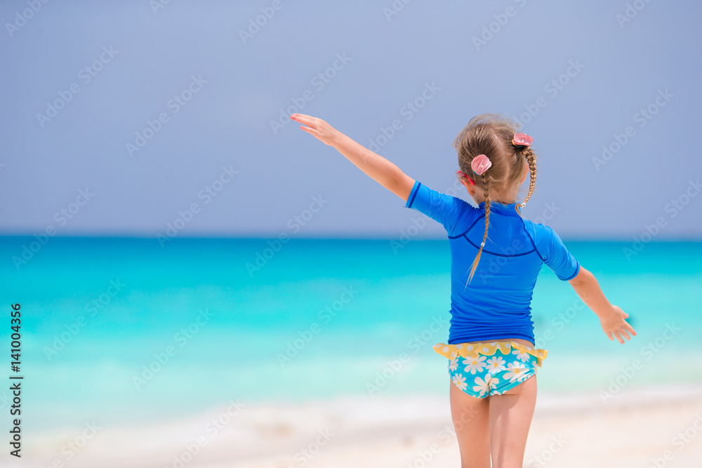 Adorable little girl during beach vacation having fun in shallow water ...