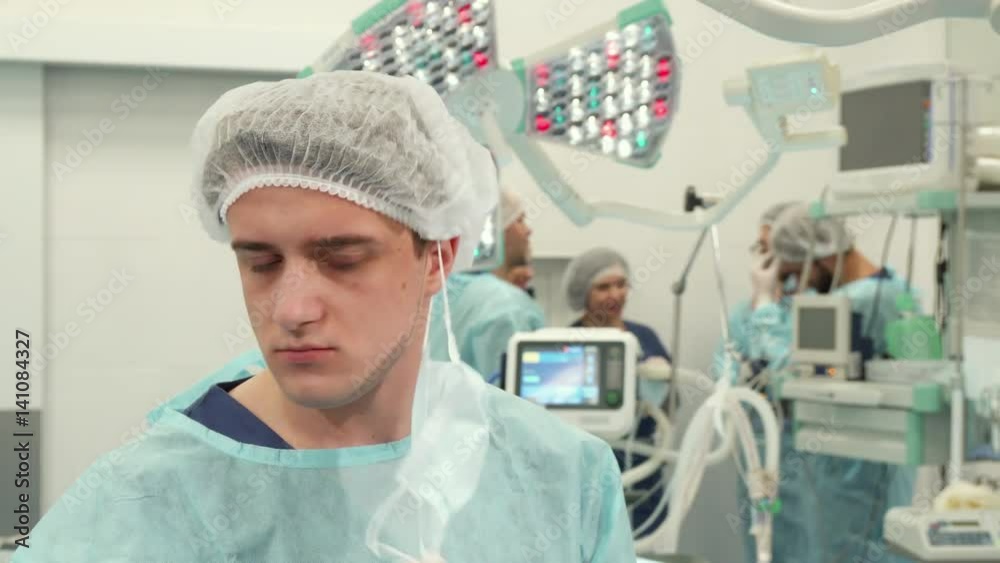 Close up of young surgeon finishing surgery. Caucasian male doctor ...