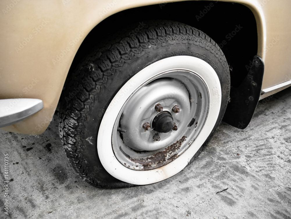 Flat tire of old car, detail and close up, nostalgia for a time which ...