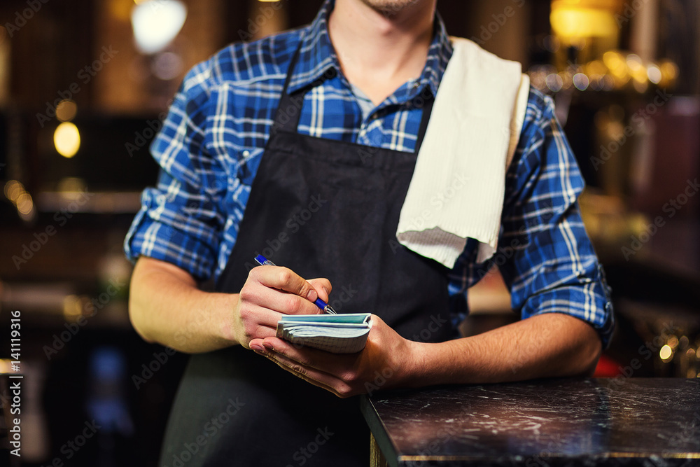 Barman at work in pub,Portrait of cheerful barman worker standing ...