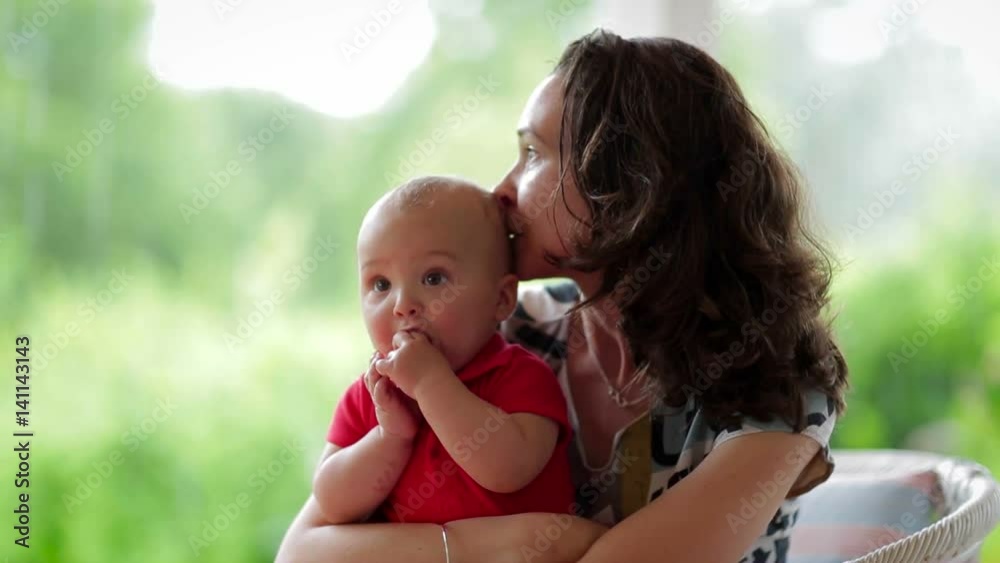 Mother kissing her baby in a sweet and spontaneous way. Sincere candid ...