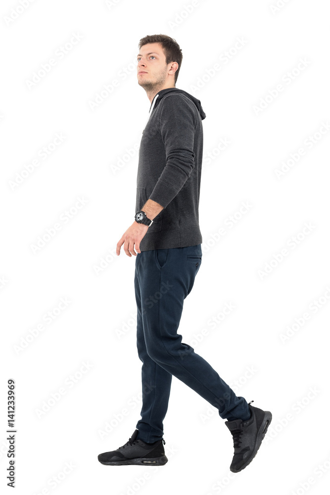 Side view of young handsome sporty man in sweatshirt and sweat pants ...