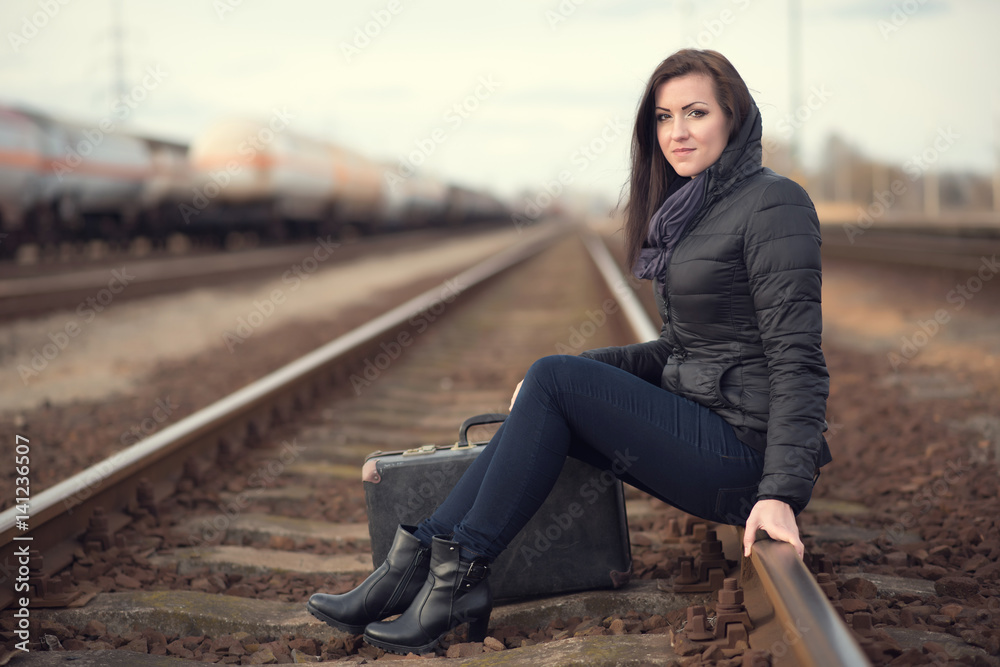 Sad woman sitting on train tracks Stock Photo | Adobe Stock