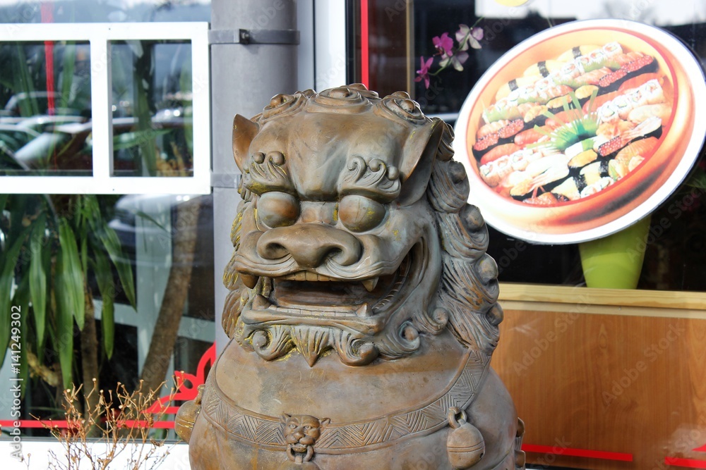 Guardian lions or Fo-dogs flank the entrance gates Buddhist temple. The ...