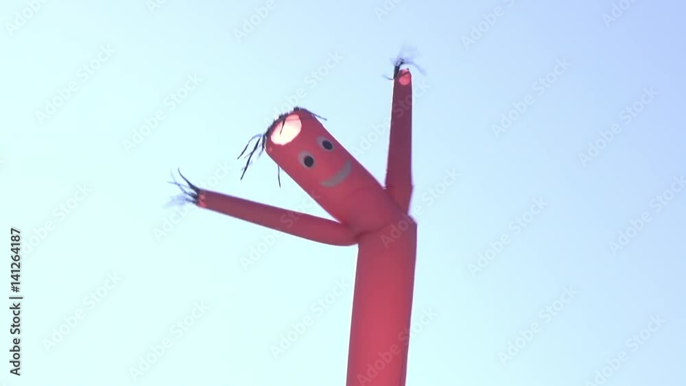 Super wiggly inflatable armed balloon man blowing in wind on blue sky ...