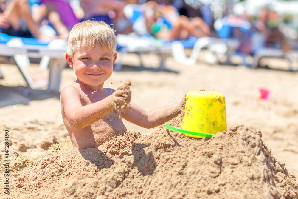 boy buried in sand on the sea beach Stock Photo | Adobe Stock