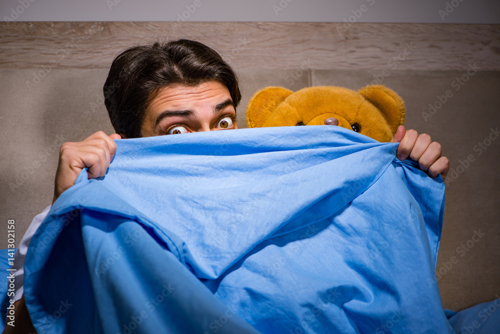 Young man scared in bed Stock Photo | Adobe Stock