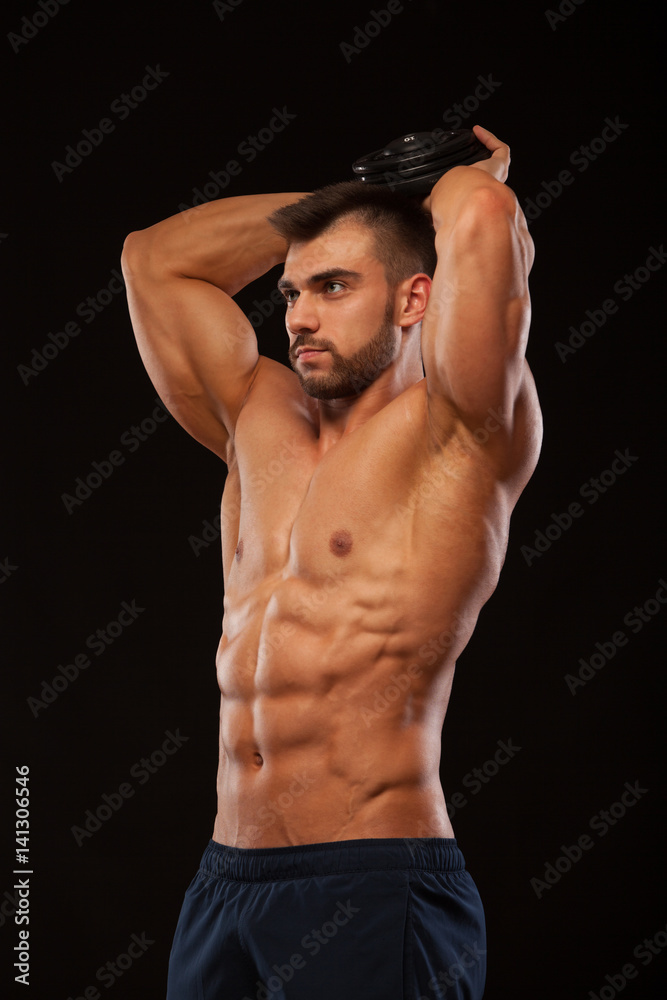 Strong man making exercises on triceps with a dumbbell. Close up shot ...