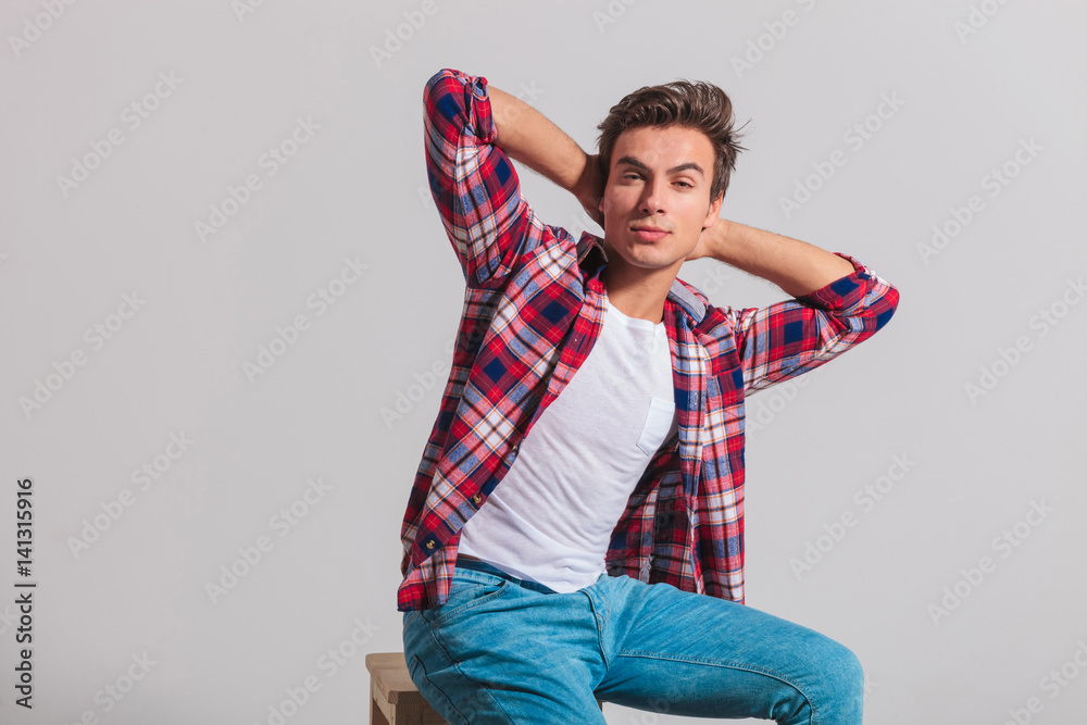 young casual man sitting and holding his hands behind head Stock Photo ...