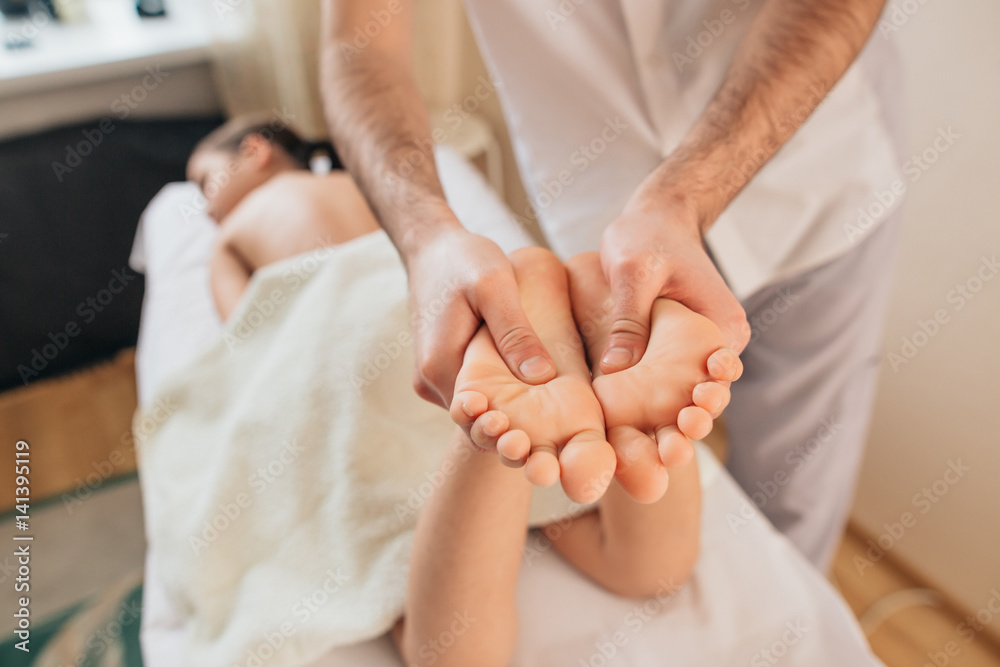 Masseur massaging little girl foot. Stock-Foto | Adobe Stock