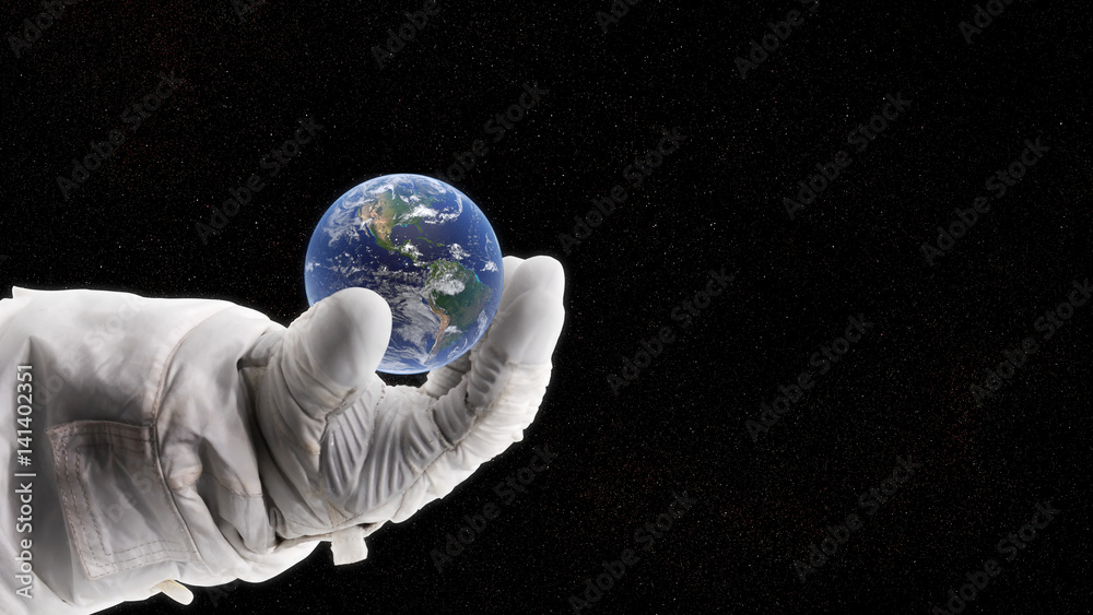 astronaut’s hand holding planet Earth in deep space - conceptual ...