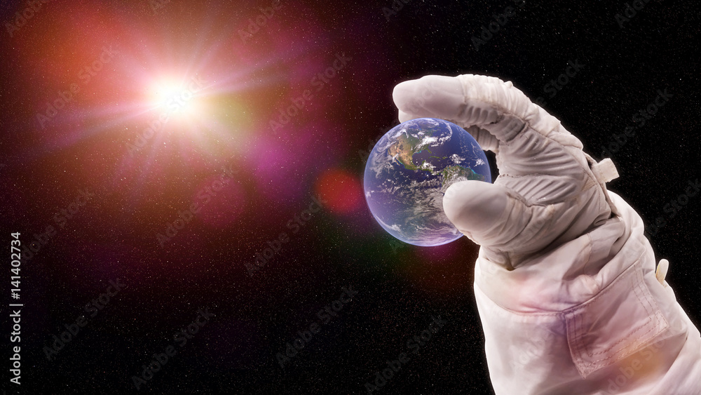 astronaut’s hand holding planet Earth towards a bright sun Stock ...