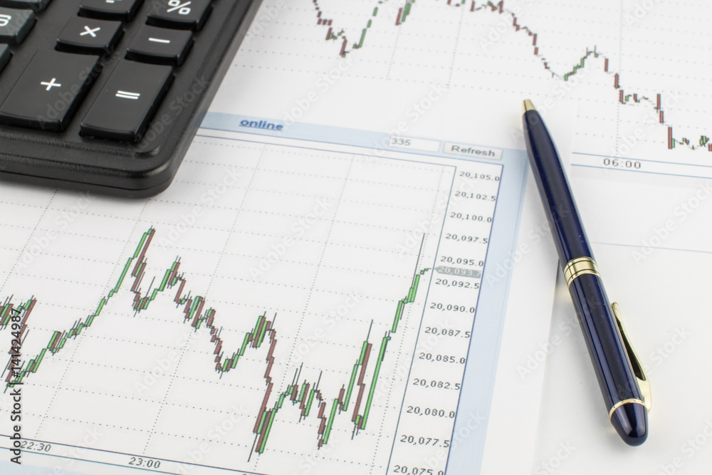 Calculator, pen and financial graph on a white background business ...