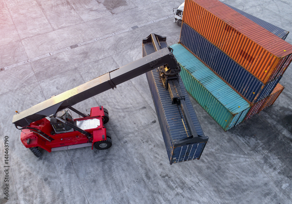 stacker forklift working on lifting containers in yard in aerial view ...