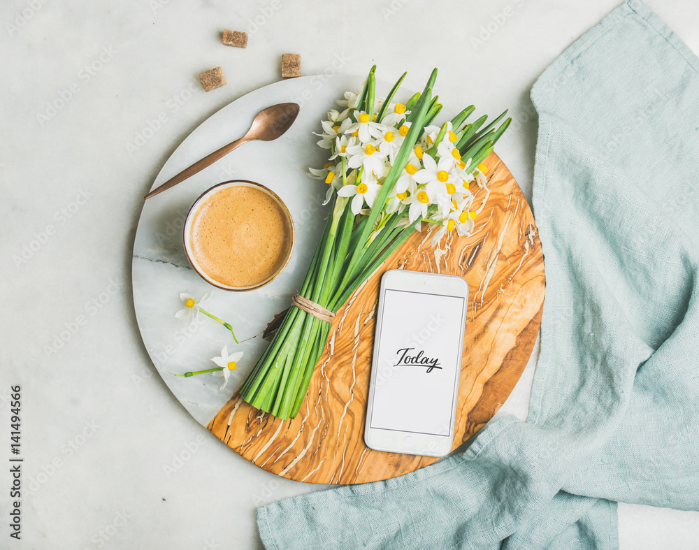 Cup of morning coffee, bucket of spring flowers and mobile phone with ...