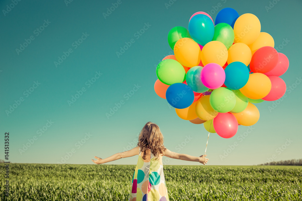 Child with toy balloons in spring field Stock Photo | Adobe Stock