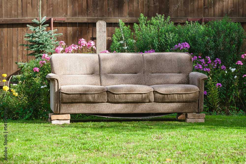 old sofa placed on bricks in green garden Stock Photo | Adobe Stock