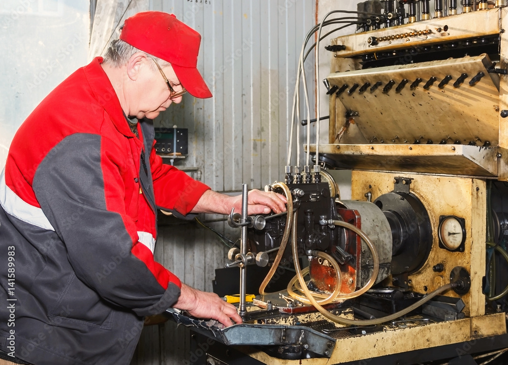 Professional mechanics testing diesel injector in his workshop, repair ...