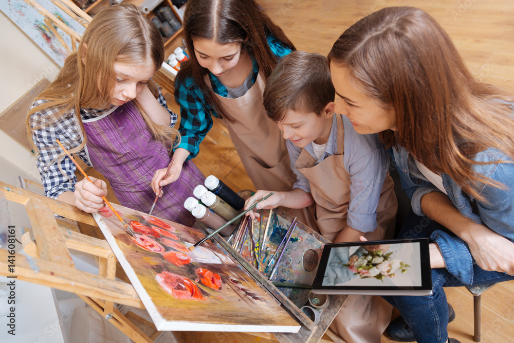 Happy young teacher painting with kids in the art school Stock Photo ...