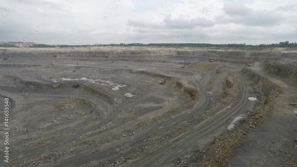Video footage taken from a height over a giant quarry. Flight over a ...