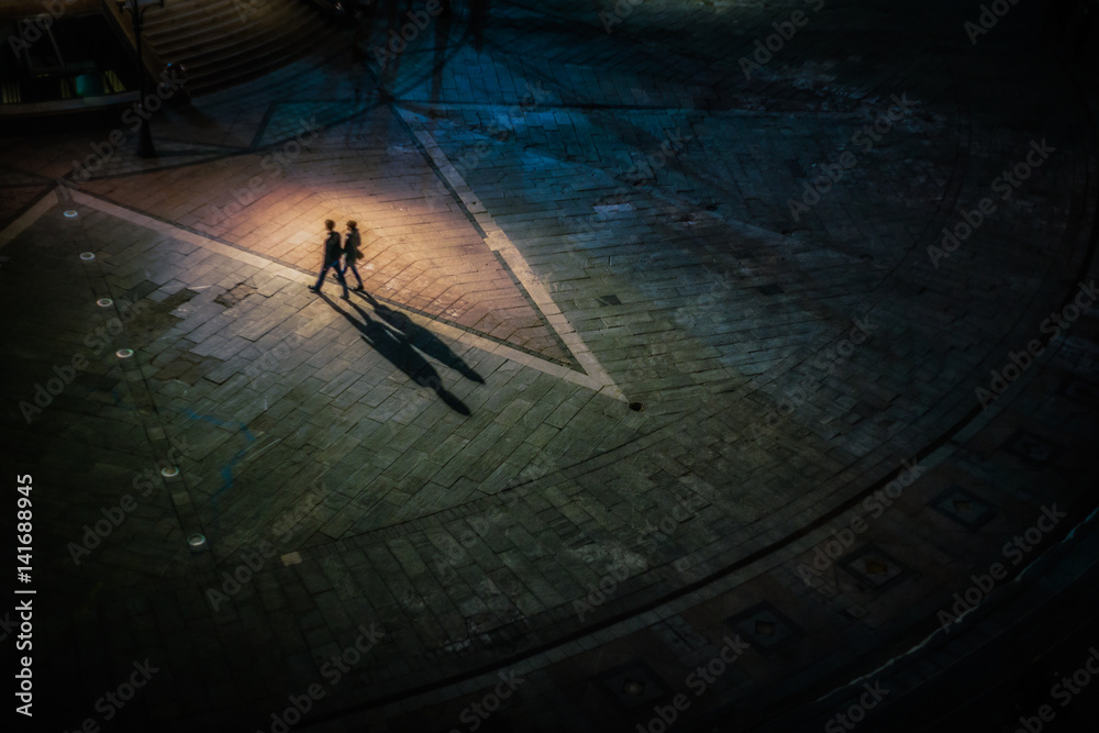 Street lamp light in the night cast rays on the street. Vivid lowlight ...