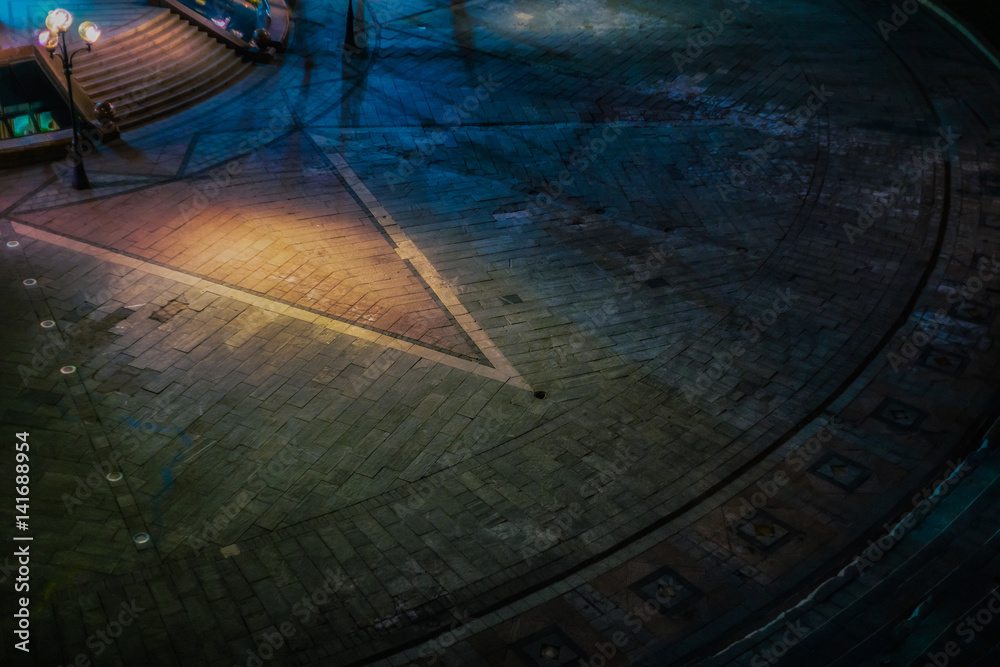 Street lamp light in the night cast rays on the street. Vivid lowlight ...