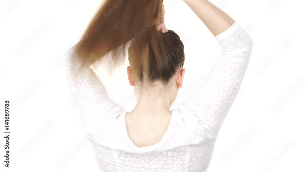 Vidéo Stock Woman tying her long smooth hair in ponytail, making hairdo ...
