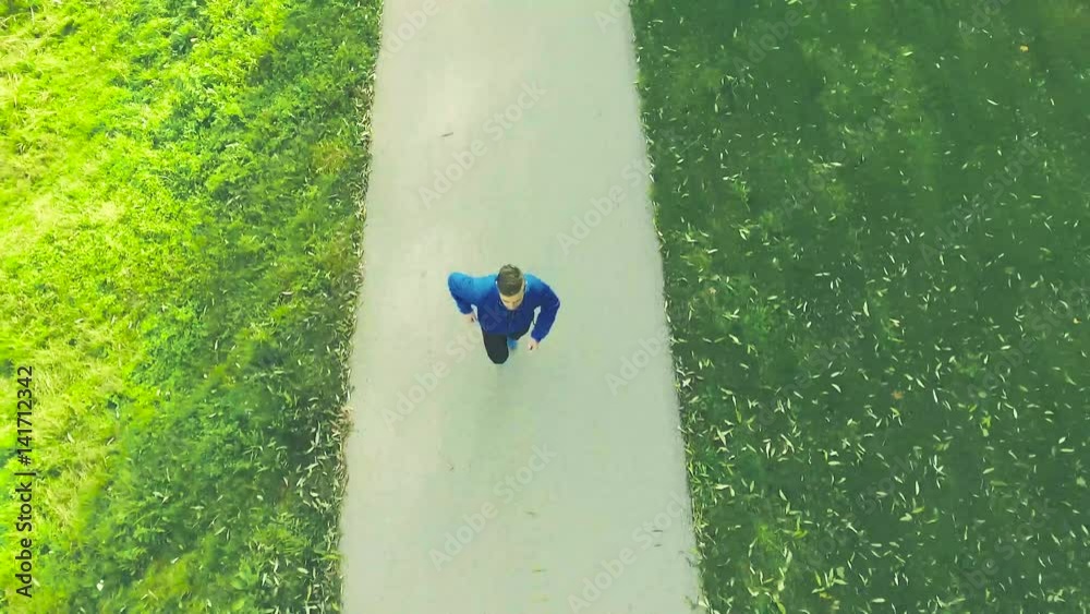 Young athlete running in green nature on asphalt path Stock Video ...