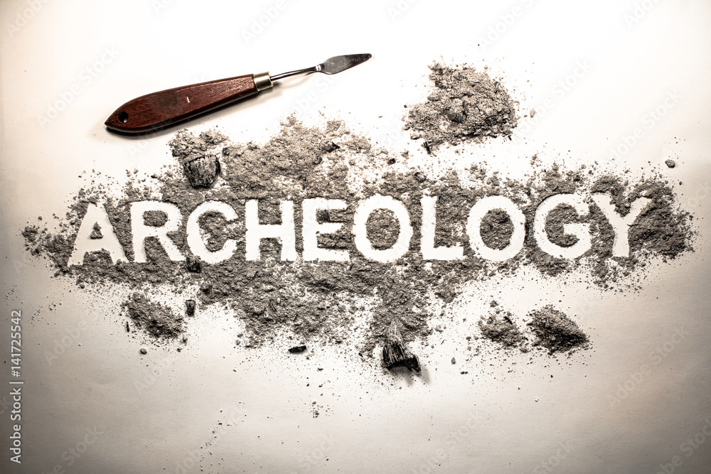Archeology word written in letters on a pile of ash, dirt, soil, ground ...