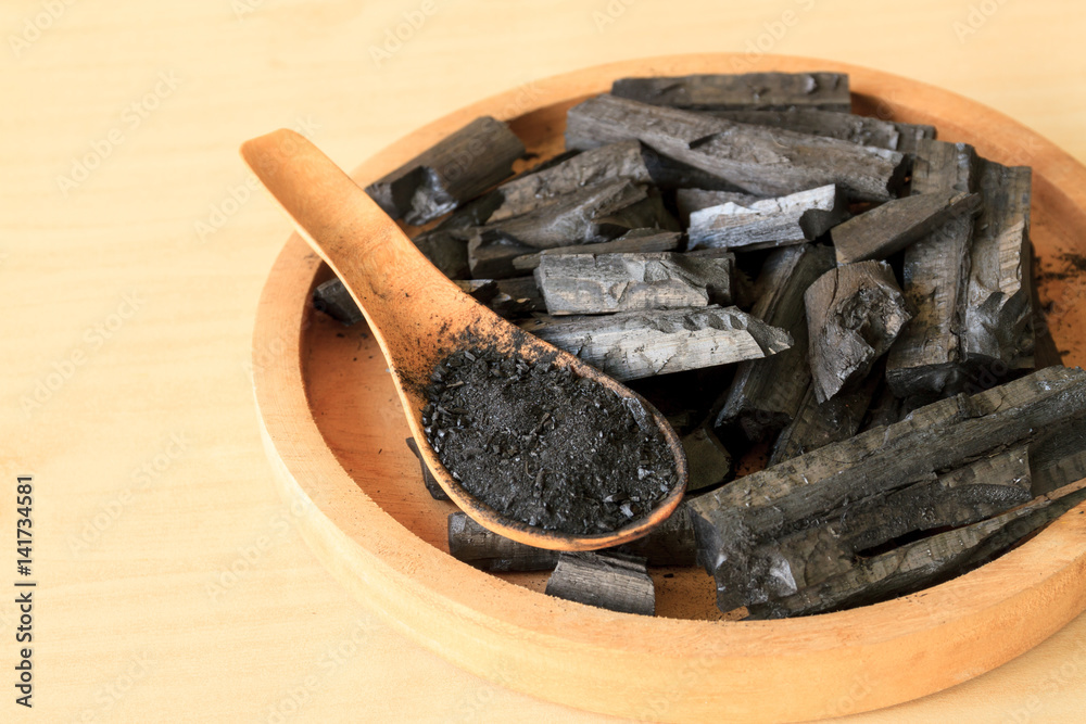 Charcoal and charcoal powder on wooden table background. Stock Photo ...