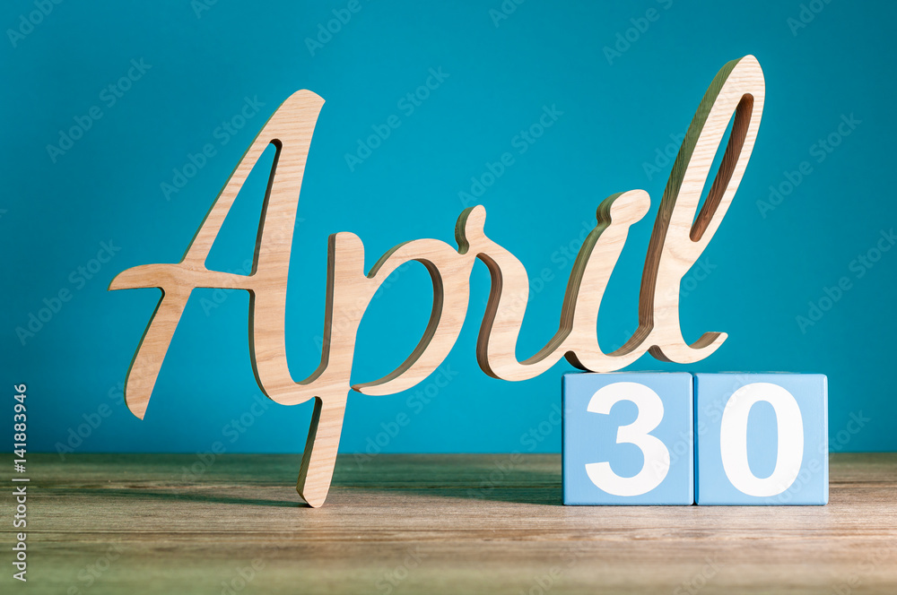 April 30th. Day 30 of month, daily calendar on desk with blue ...