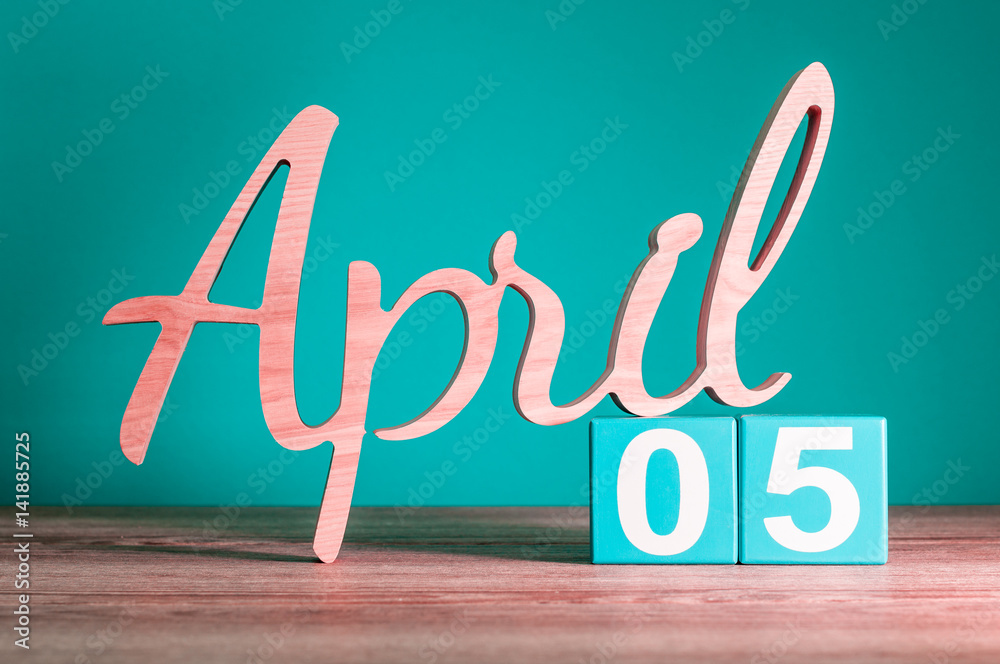 April 5th. Day 5 of month, daily calendar on wooden table with green ...