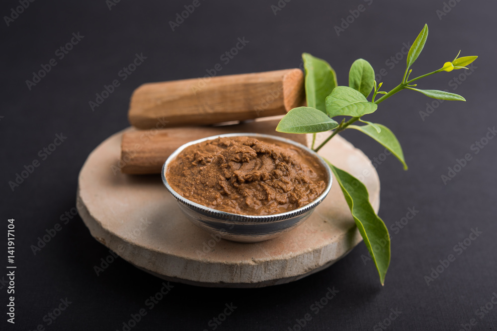 Ayurvedic Chandan powder or sandalwood paste in silver bowl with sticks ...