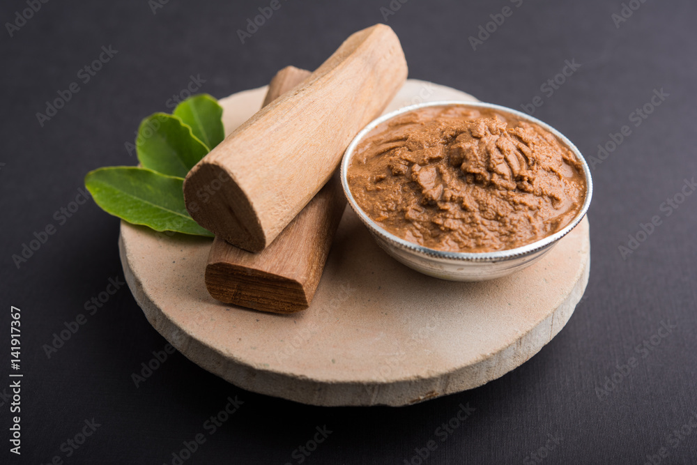 Ayurvedic Chandan powder or sandalwood paste in silver bowl with sticks ...