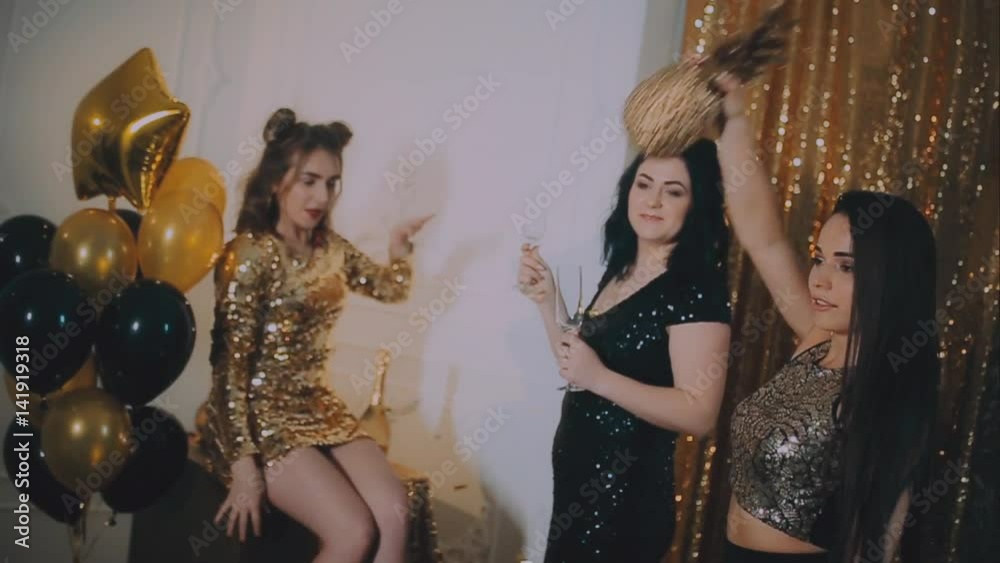 Celebration. Beautiful girls are happy. On a gold background with ...