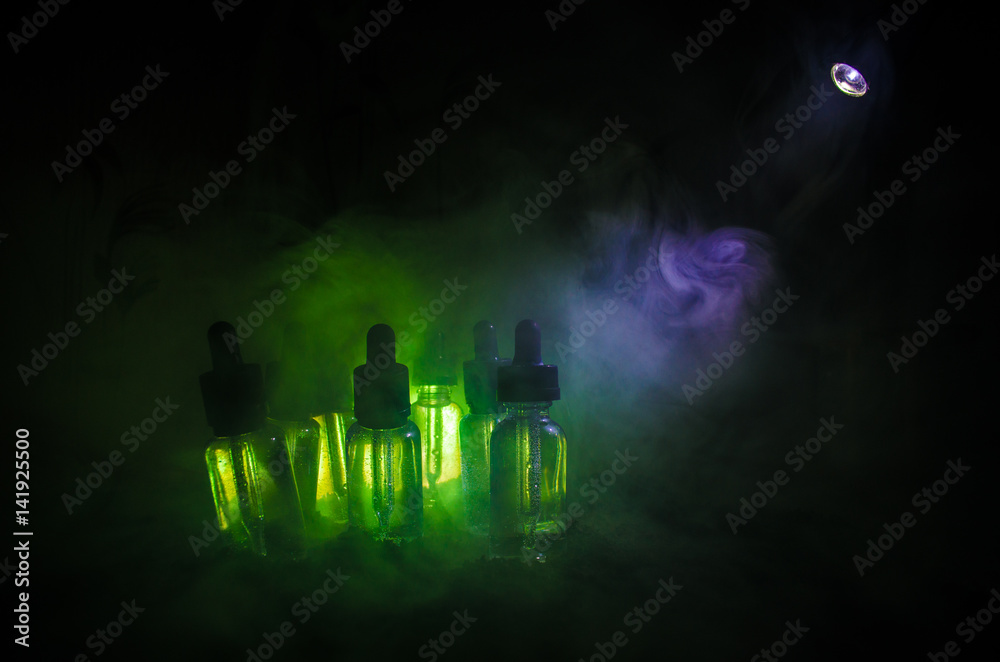 Vape concept. Smoke clouds and vape liquid bottles on dark background ...