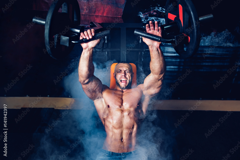 The athlete doing exercises on pectoral muscles in smoke. GYM Stock ...